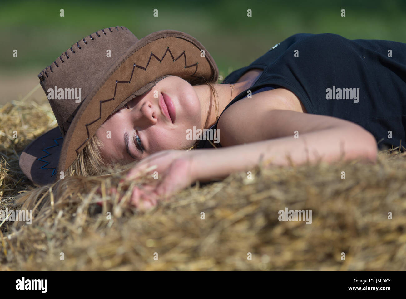 Pretty young girl on a haystack Stock Photo - Alamy
