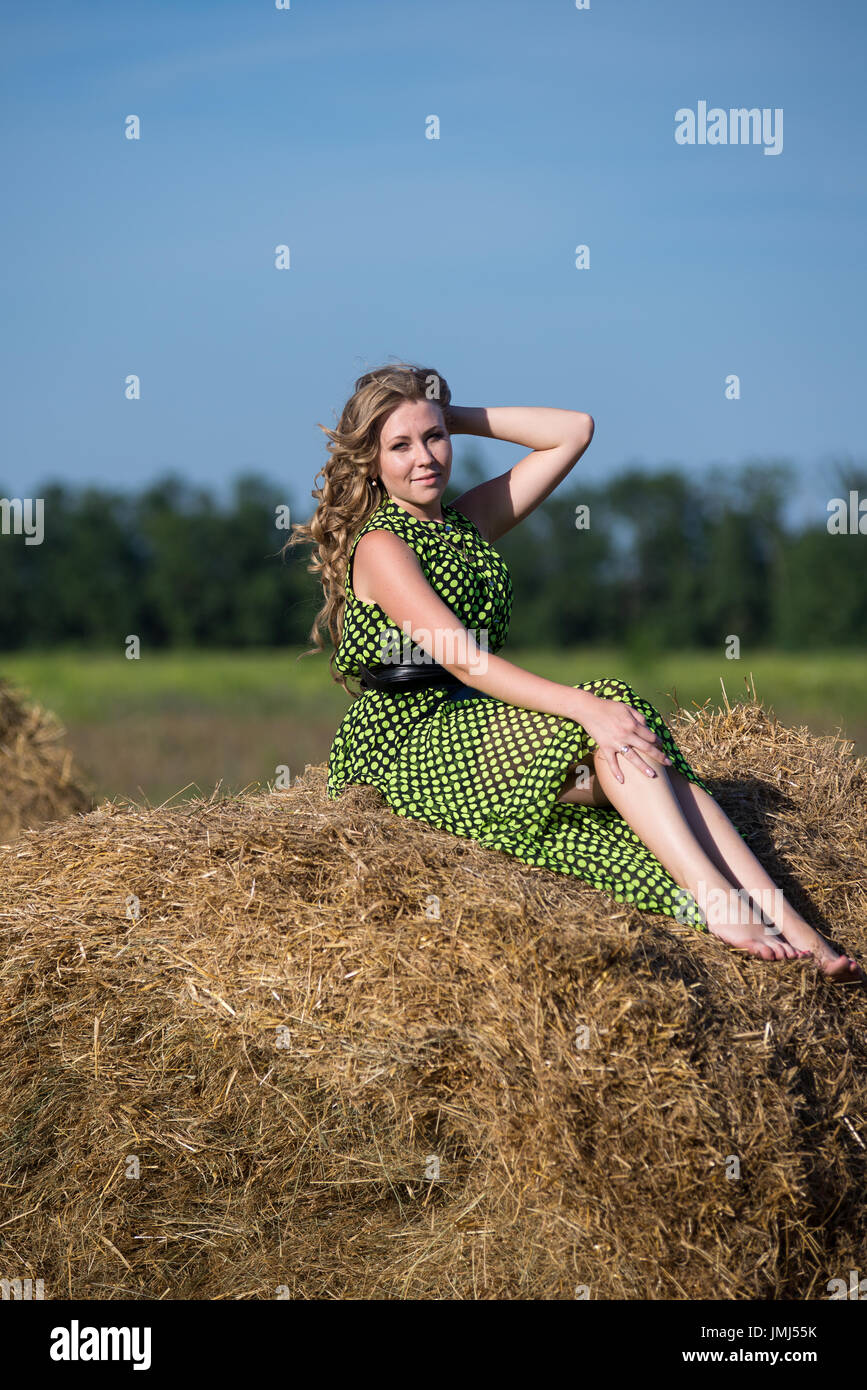 Pretty young girl on a haystack Stock Photo - Alamy