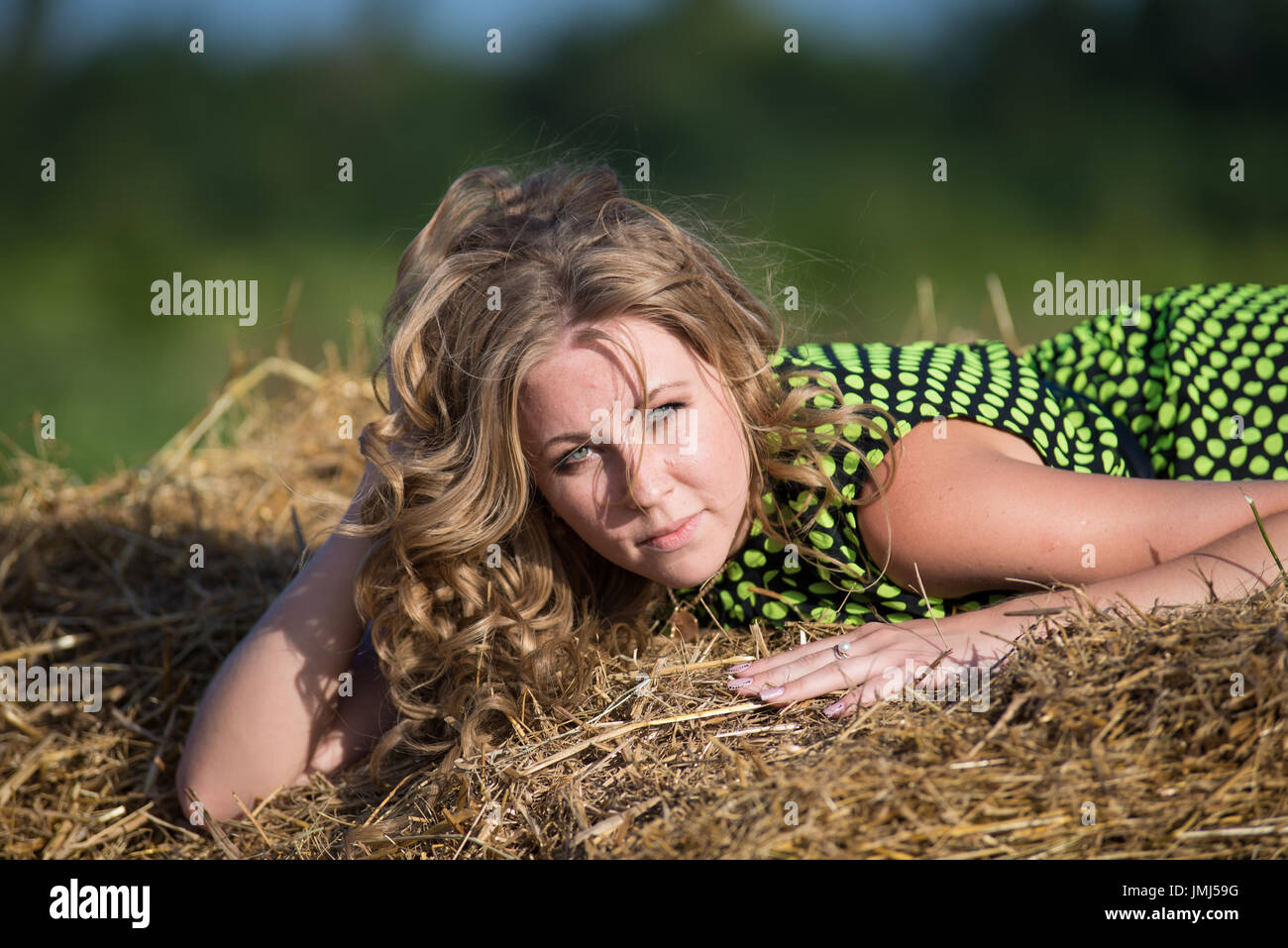 Pretty young girl on a haystack Stock Photo - Alamy