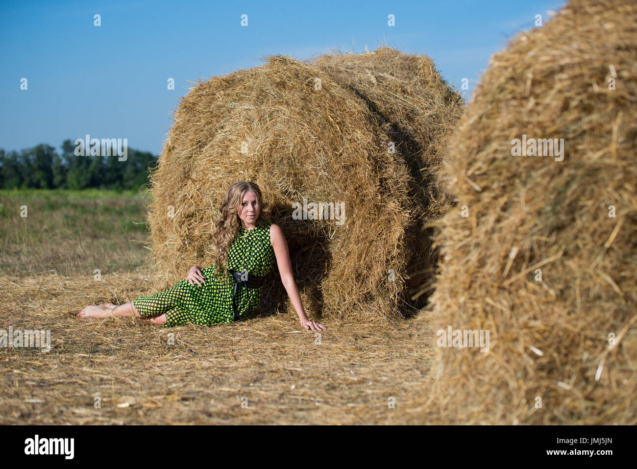 Pretty young girl on a haystack Stock Photo - Alamy