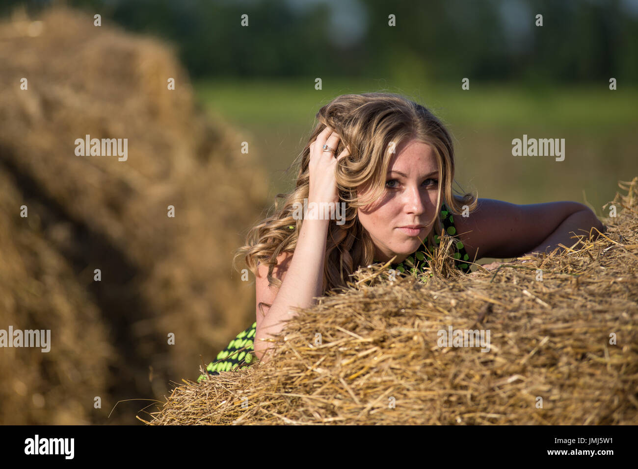 Pretty young girl on a haystack Stock Photo - Alamy
