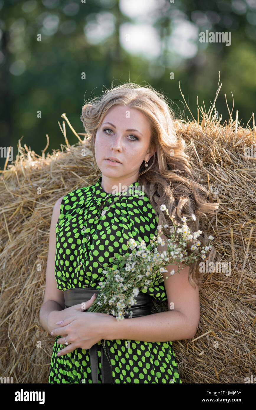 Pretty young girl on a haystack Stock Photo - Alamy