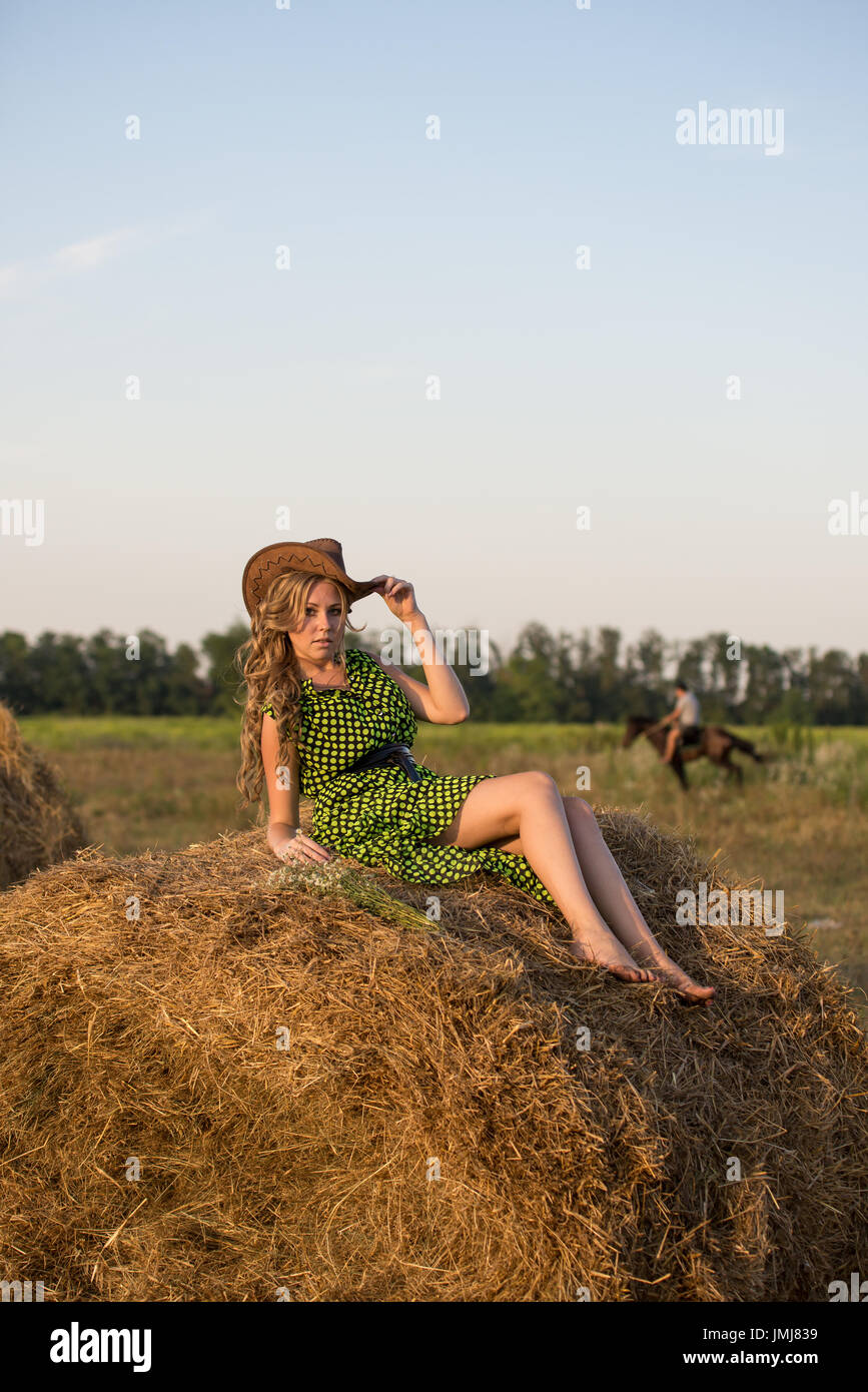 Pretty young girl on a haystack Stock Photo - Alamy