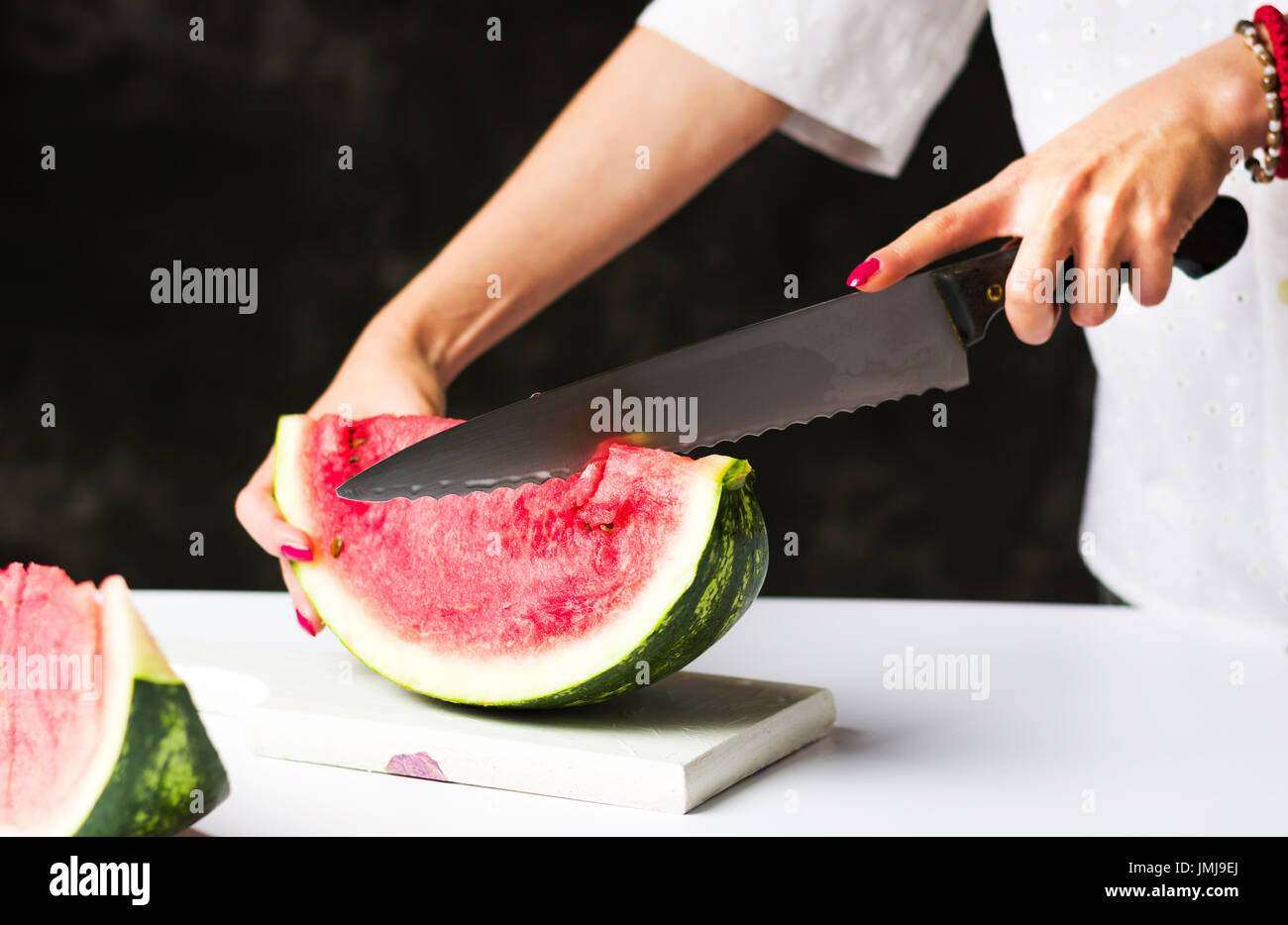 Woman slicing watermelon on a cutting board Stock Photo - Alamy