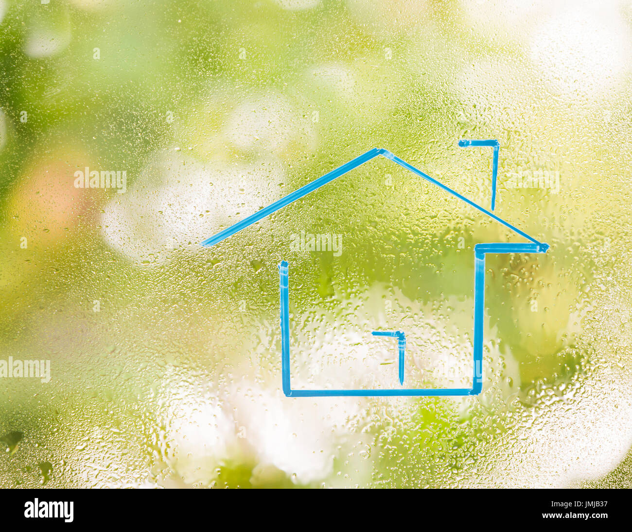 blue house shape on blurred greenery background Stock Photo - Alamy