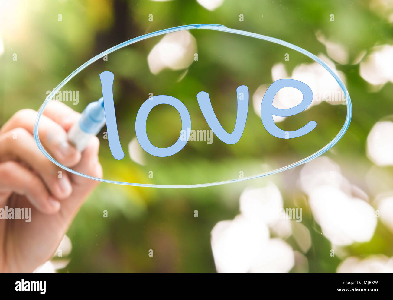 hand writing love on blurred greenery background Stock Photo - Alamy