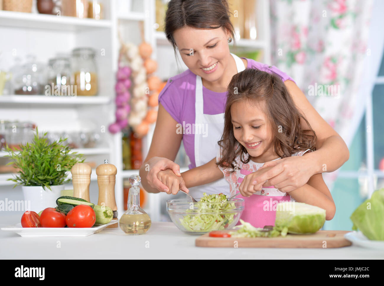 Mother and daughter preparing dinner together on kitchen Stock Photo ...