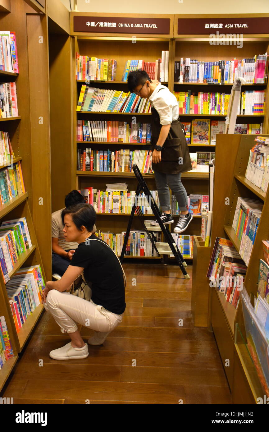 One person searches for a book as a bookstore employee puts new books ...