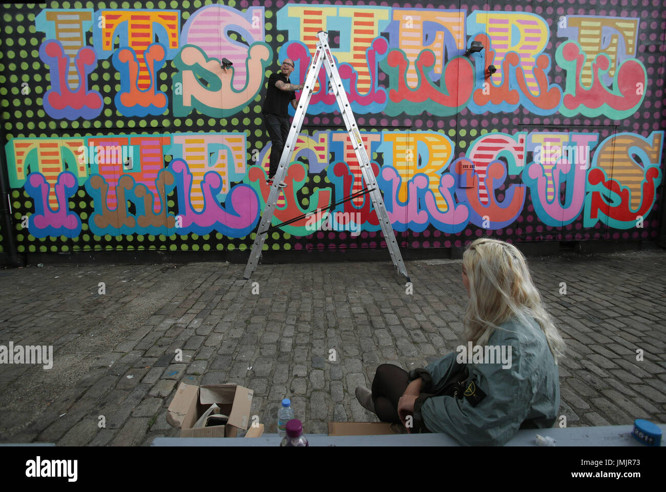 Street artist Ben Eine putting the finishing touches to his work 'Its ...