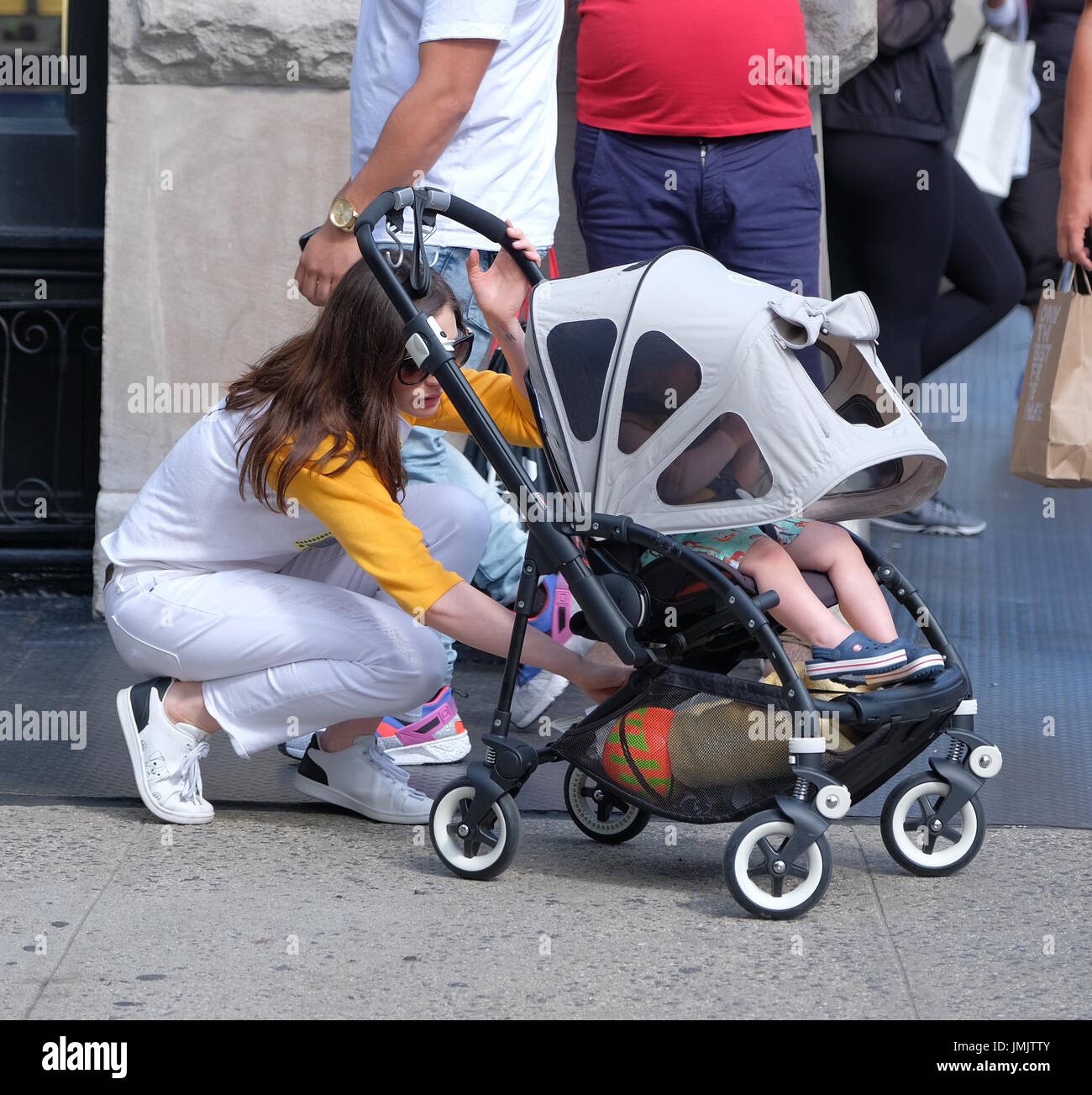 Anne Hathaway and Adam Shulman walking with their child in SOHO ...