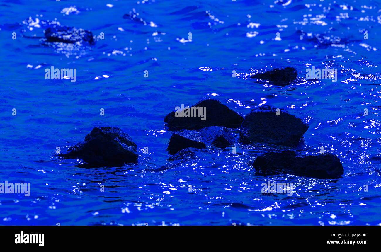 black stones in deep blue water; reflections on the water Stock Photo ...