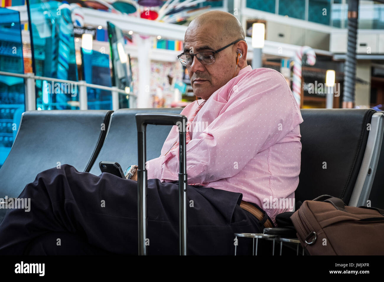 Man sitting in airport lounge Stock Photo - Alamy