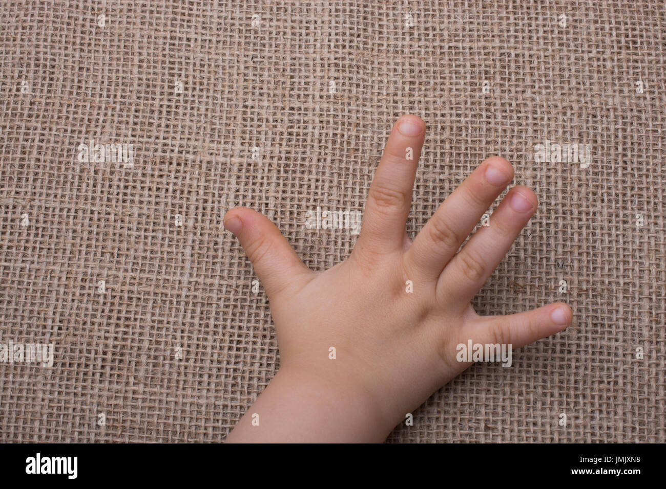 Toddler hand with canvas linen background Stock Photo - Alamy