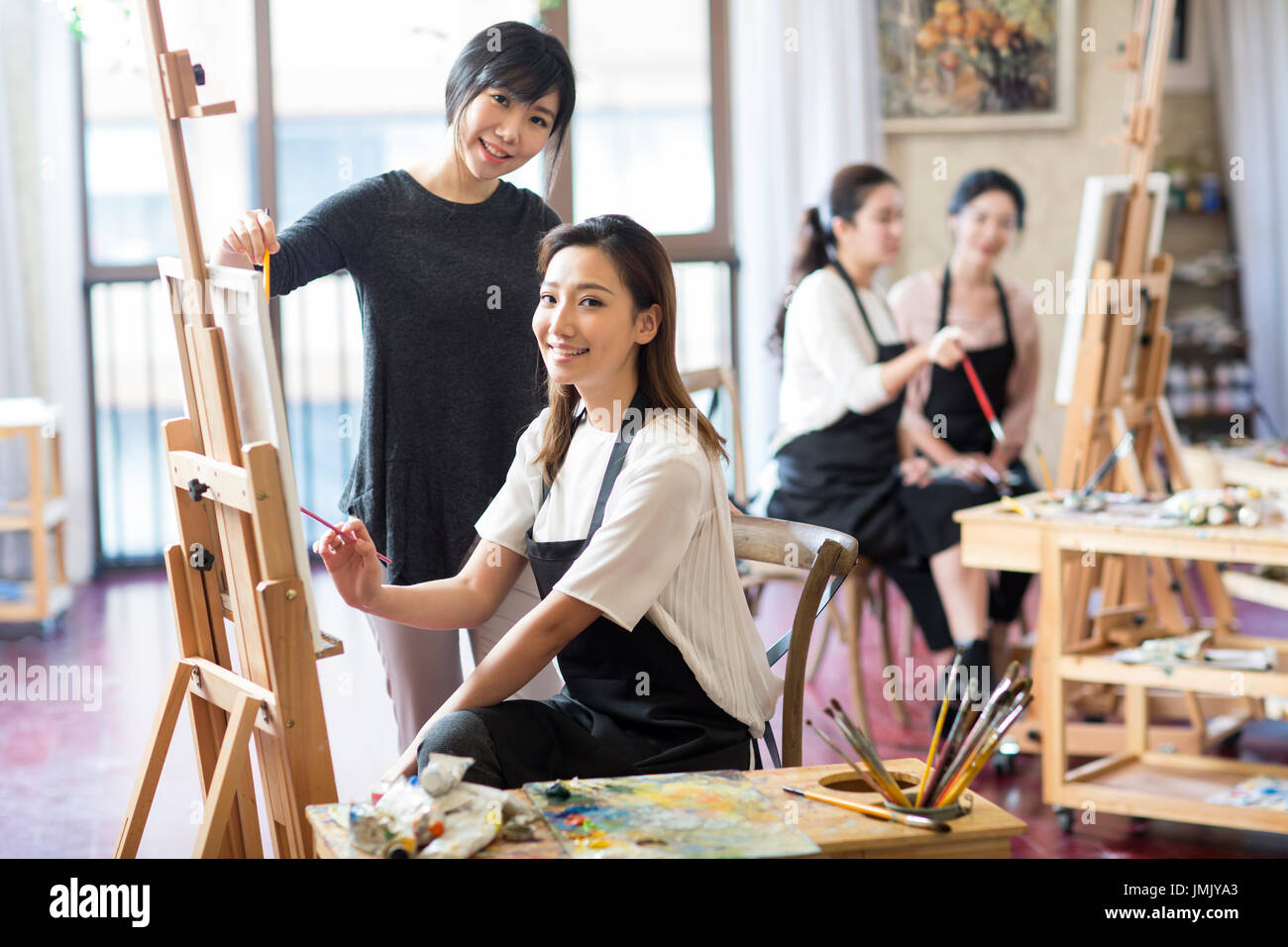 Young woman painting in art class Stock Photo - Alamy