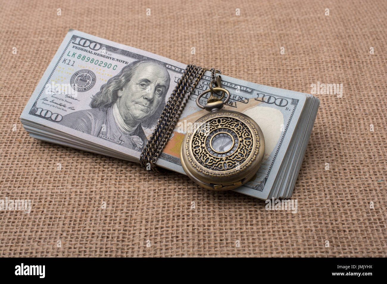 Pocket watch wrapped around banknote bundle of US dollar Stock Photo ...