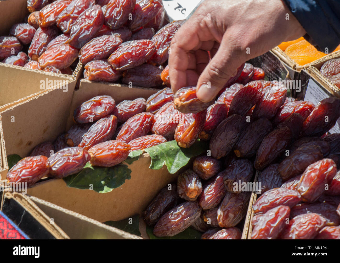 hand holding dates on a linen canvas background Stock Photo - Alamy