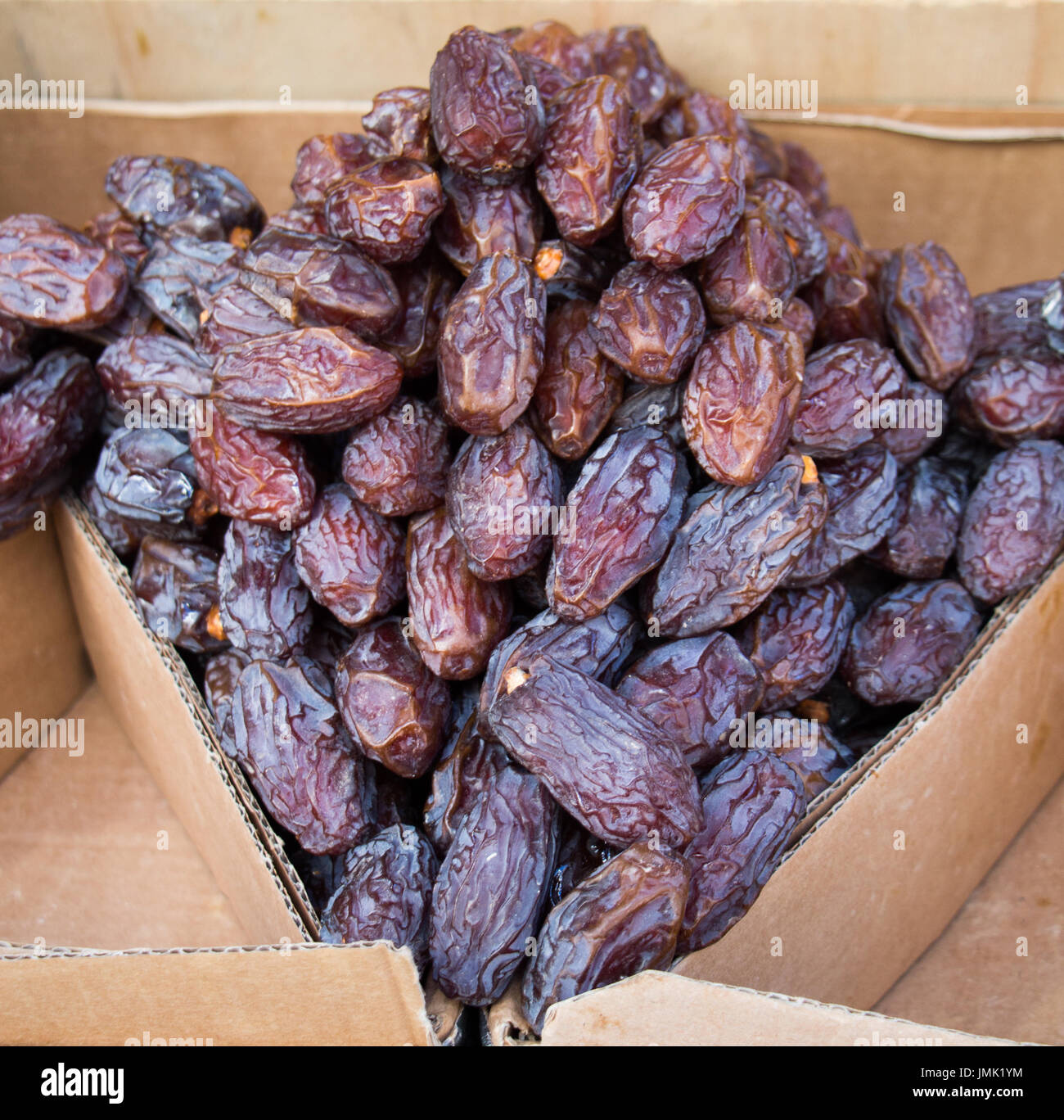 hand holding dates on a linen canvas background Stock Photo - Alamy