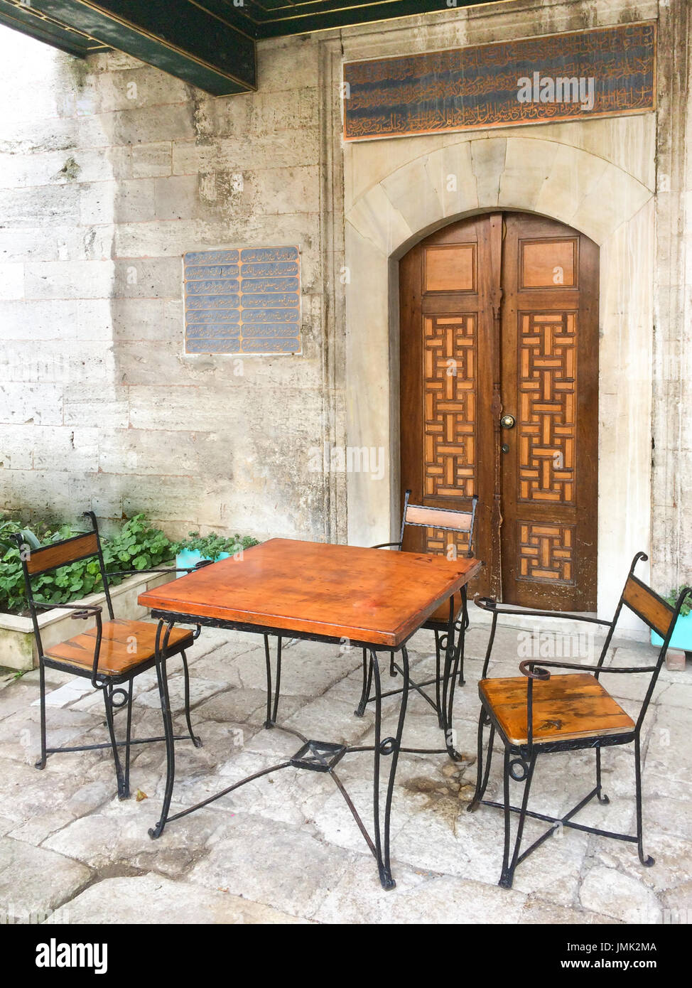 Metal and wooden table with two Arabic style chairs in front of the ...