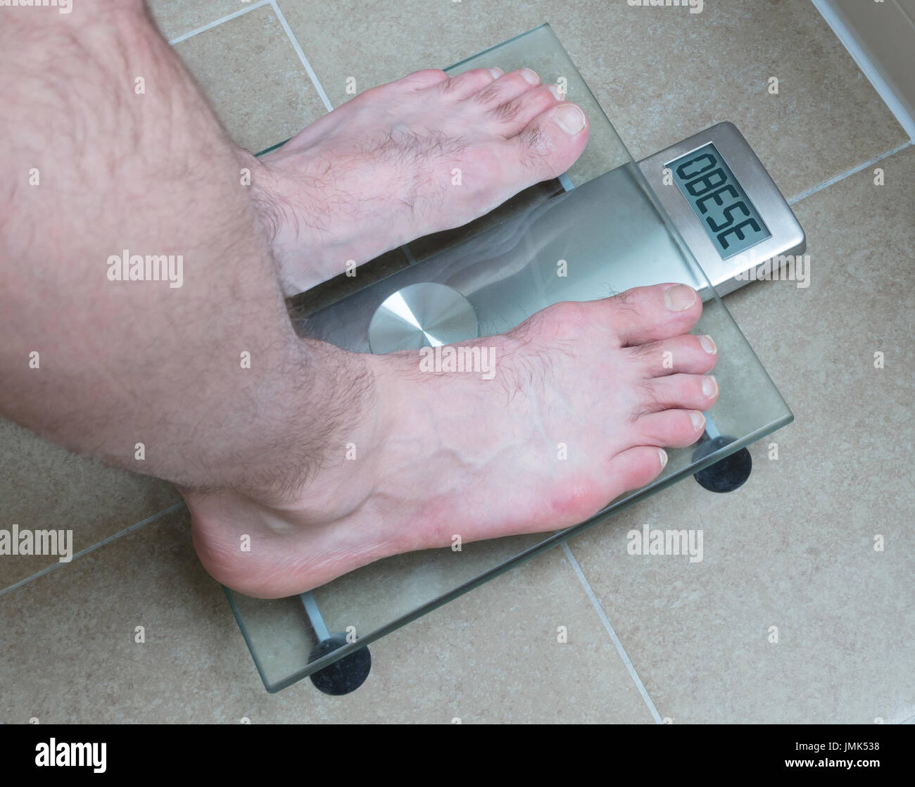 Closeup of man's feet on weight scale - Obese Stock Photo - Alamy