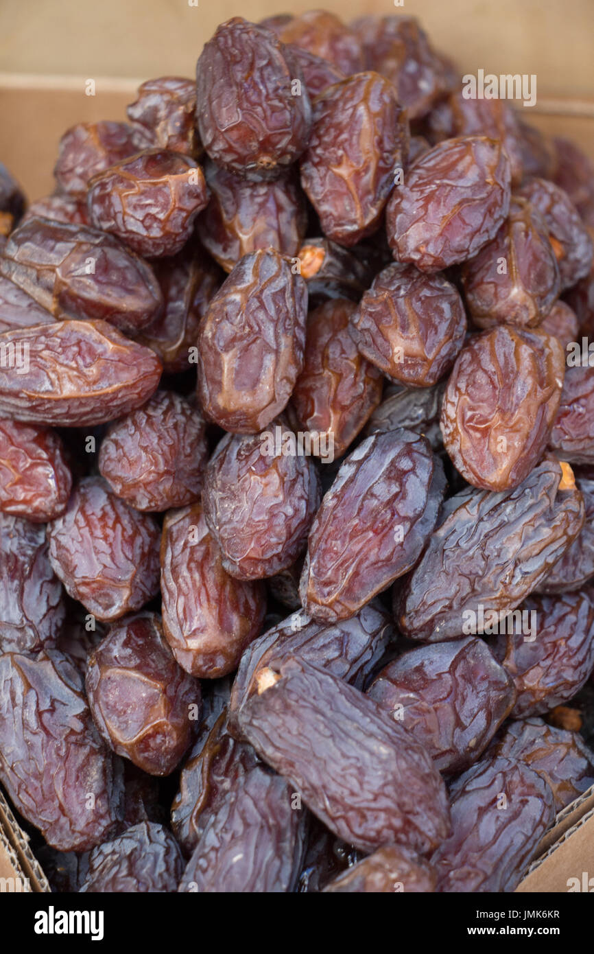 hand holding dates on a linen canvas background Stock Photo - Alamy