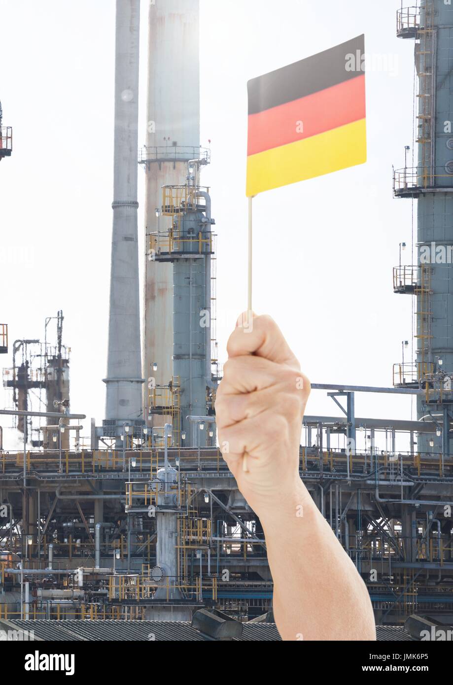 Digital composite of Hand holding German flag in front of industrial ...