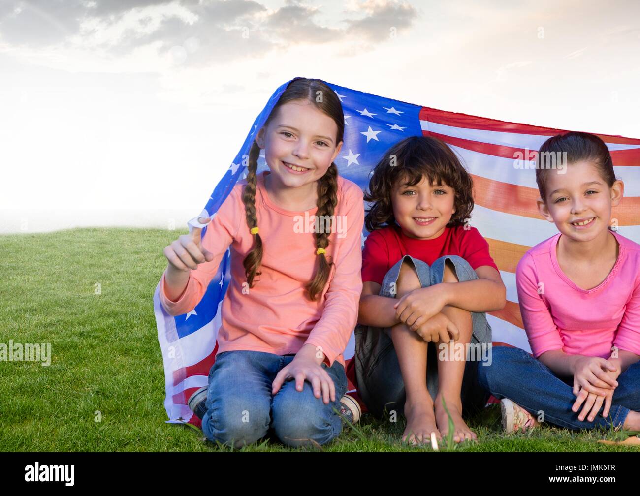Digital composite of Kids sitting under american flags in field Stock ...
