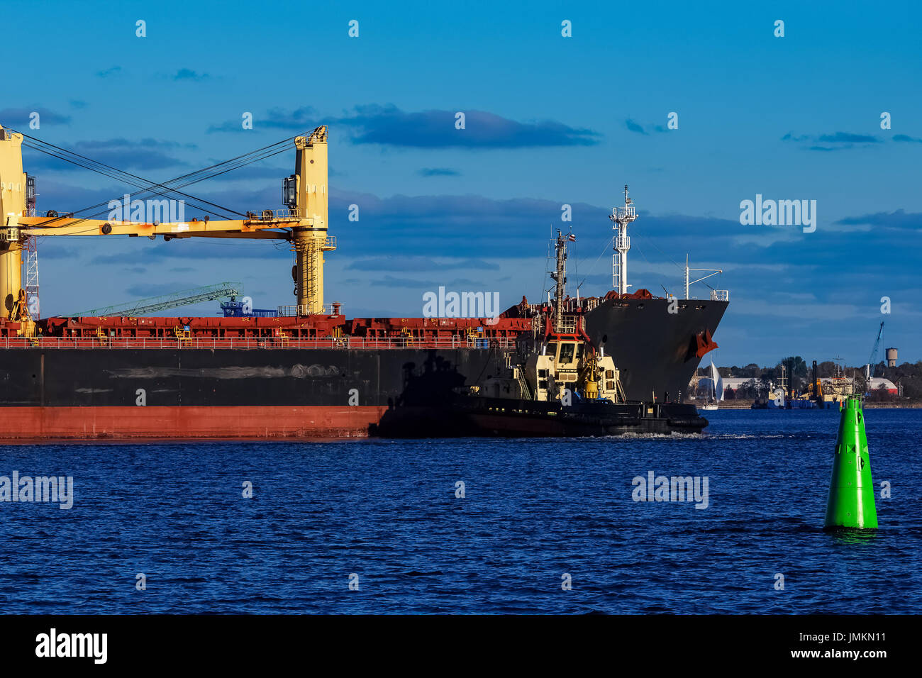Black cargo ship mooring at the port with tug ship support Stock Photo ...