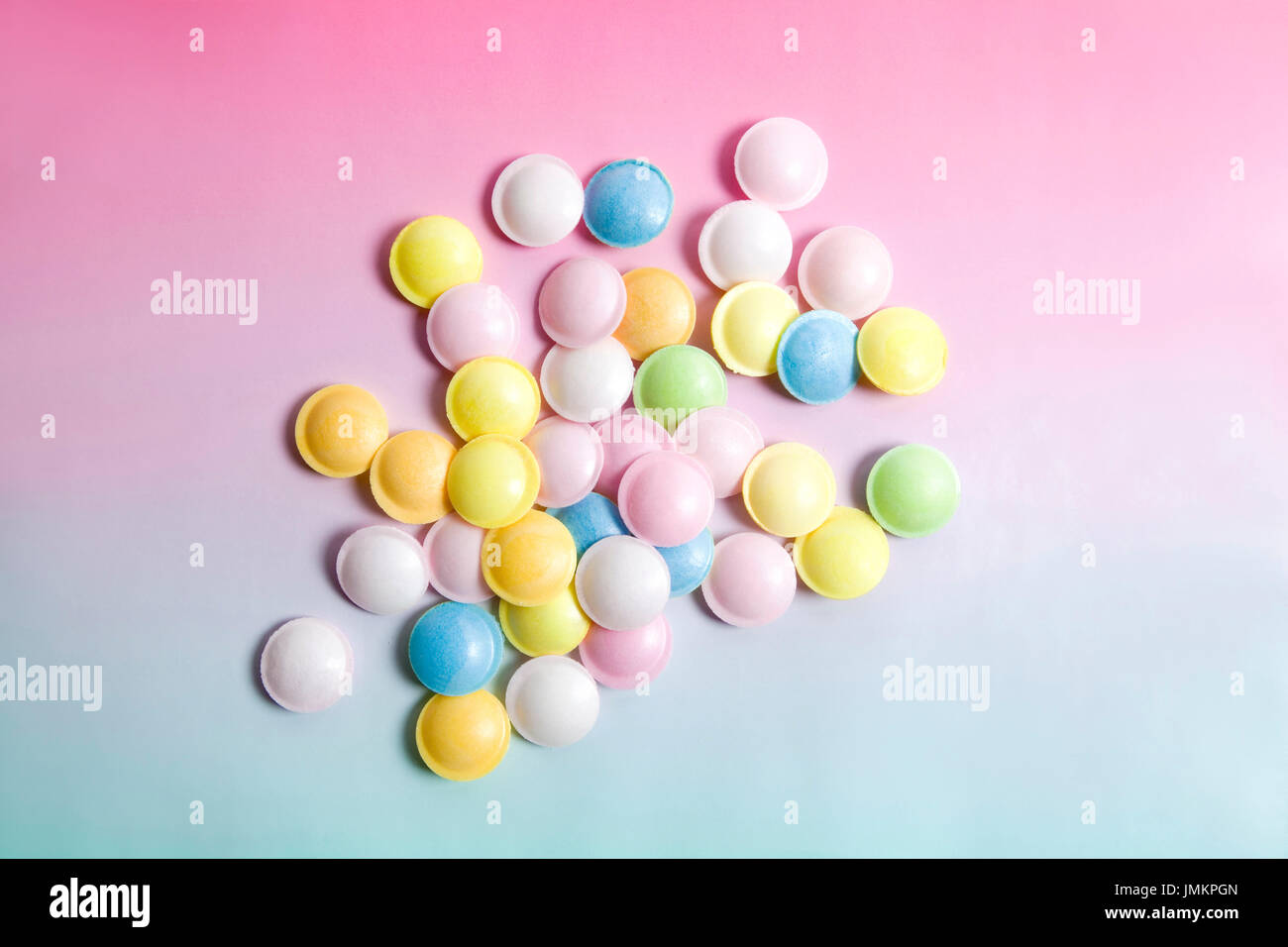 flying saucer multi coloured candy sweets on a gradient background pink ...