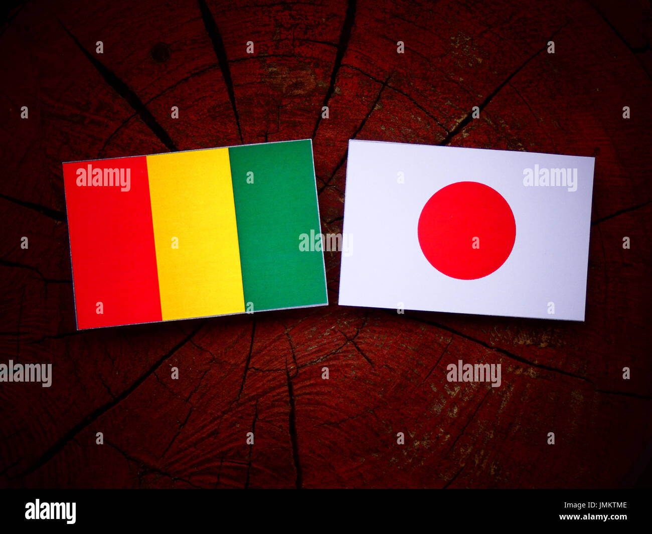 Guinean flag with Japanese flag on a tree stump isolated Stock Photo ...