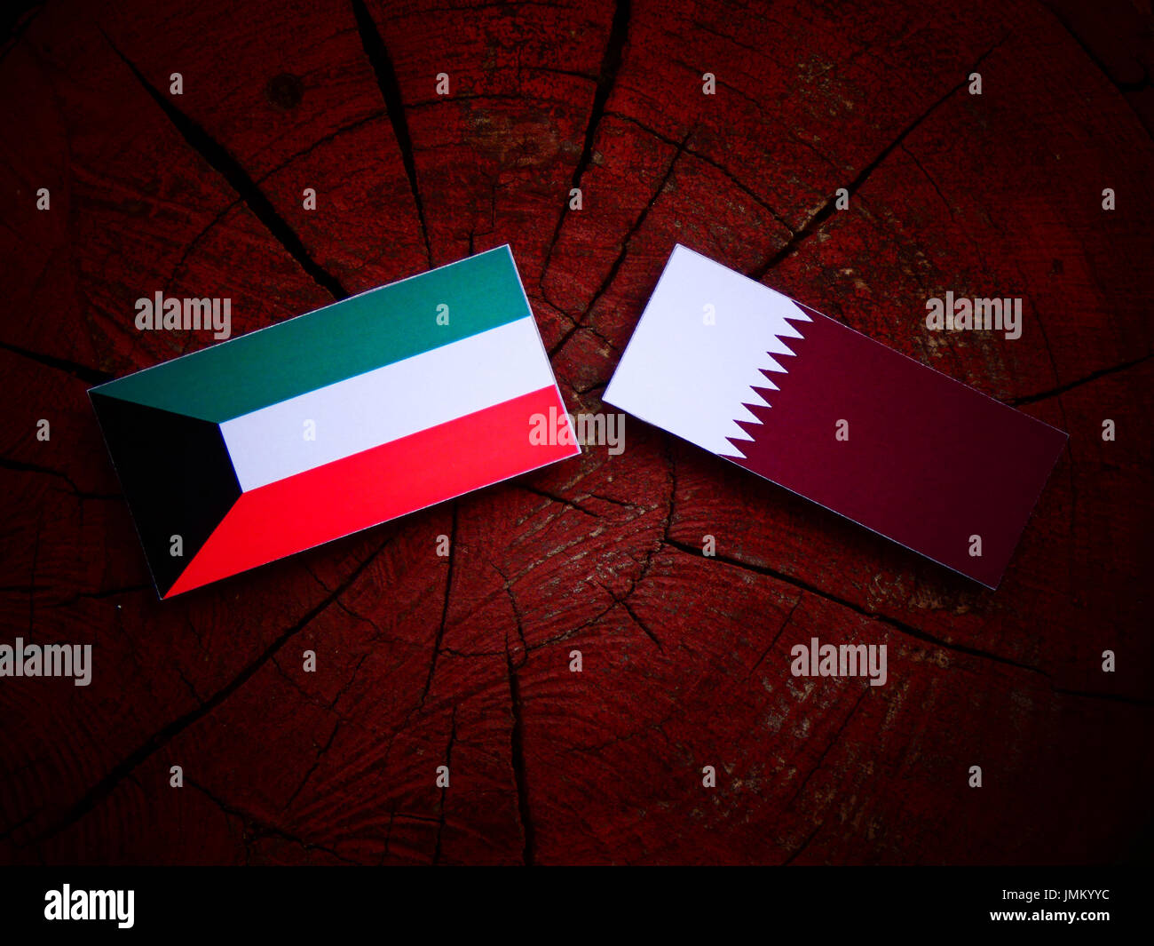 Kuwaiti flag with Qatari flag on a tree stump isolated Stock Photo - Alamy