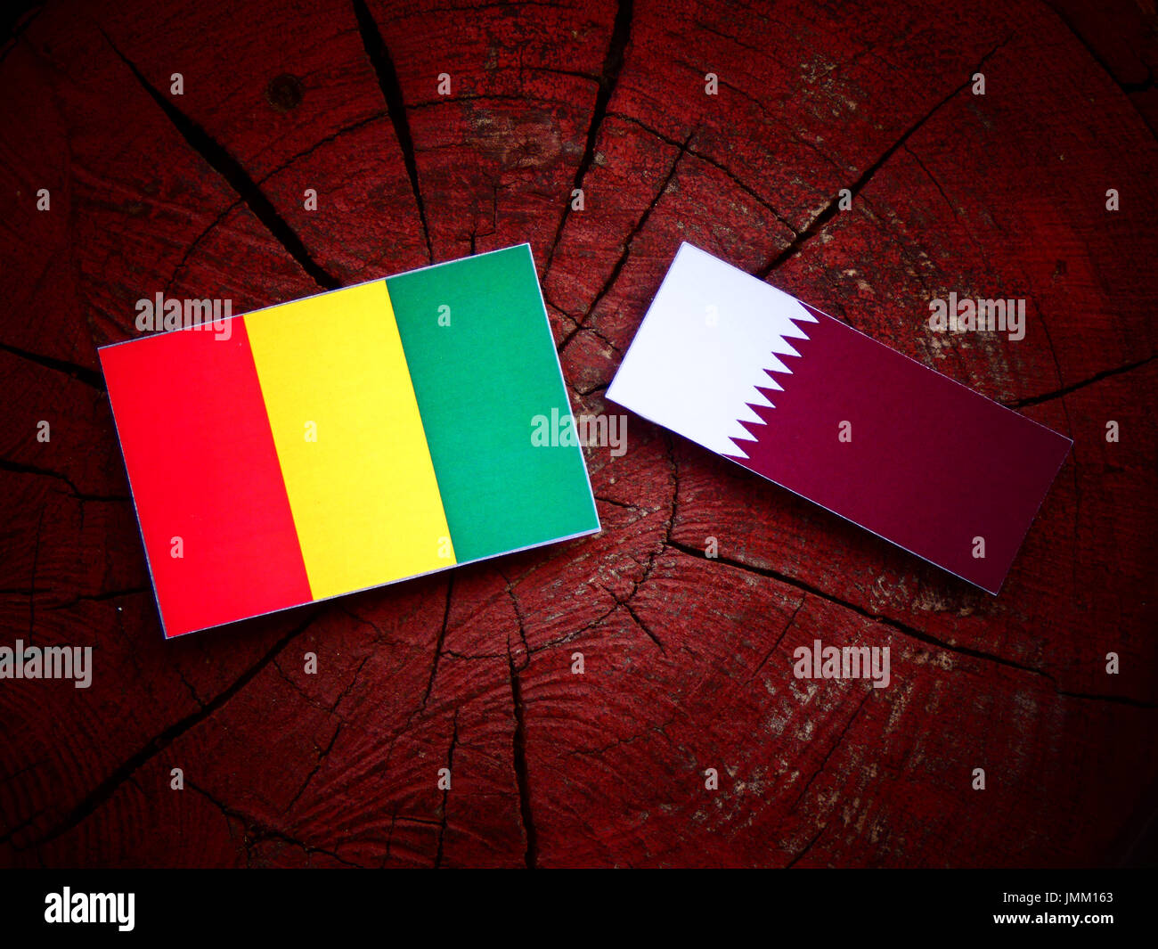 Guinean flag with Qatari flag on a tree stump isolated Stock Photo - Alamy