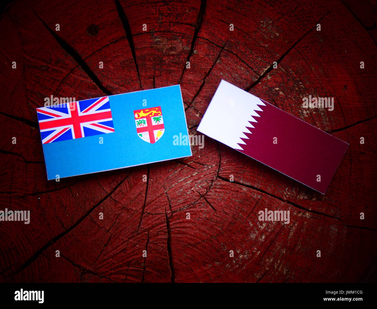 Fijian flag with Qatari flag on a tree stump isolated Stock Photo - Alamy