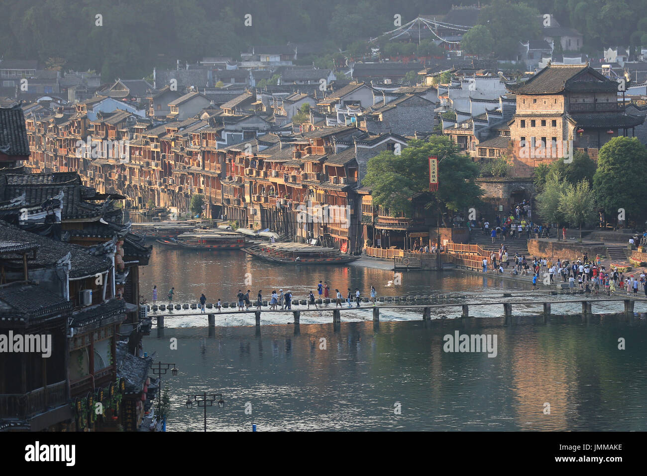 (170728) -- XIANGXI, July 28, 2017 (Xinhua) -- Visitors cross a bridge ...
