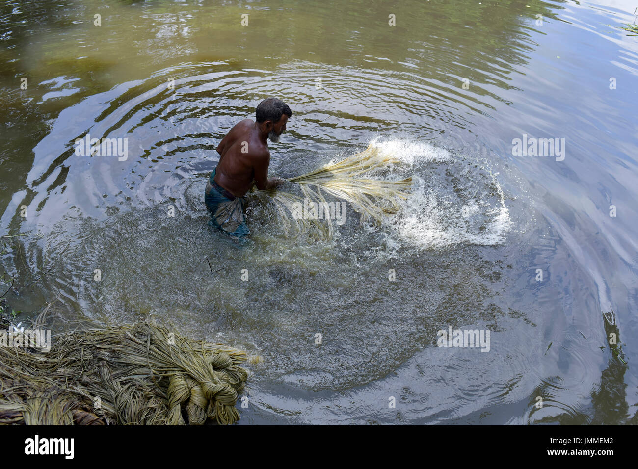 Dhaka, Bangladesh. 28th July, 2017. A Bangladeshi farmer wash jute fiber in a pond after ...