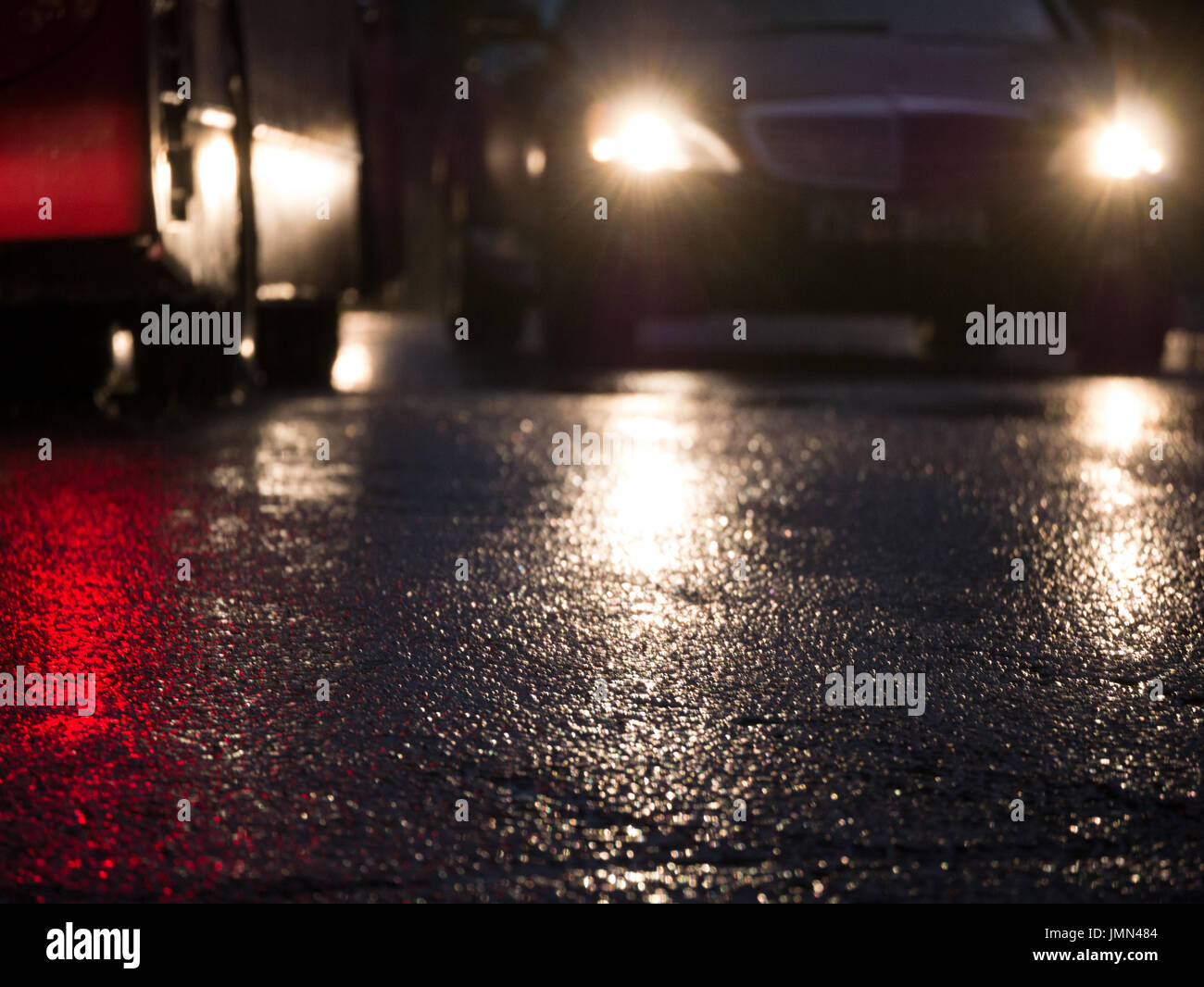 Car headlights and bus reflected on wet road Stock Photo - Alamy
