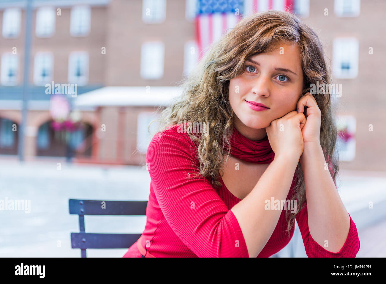 Young woman in red dress sitting smiling with American United States ...