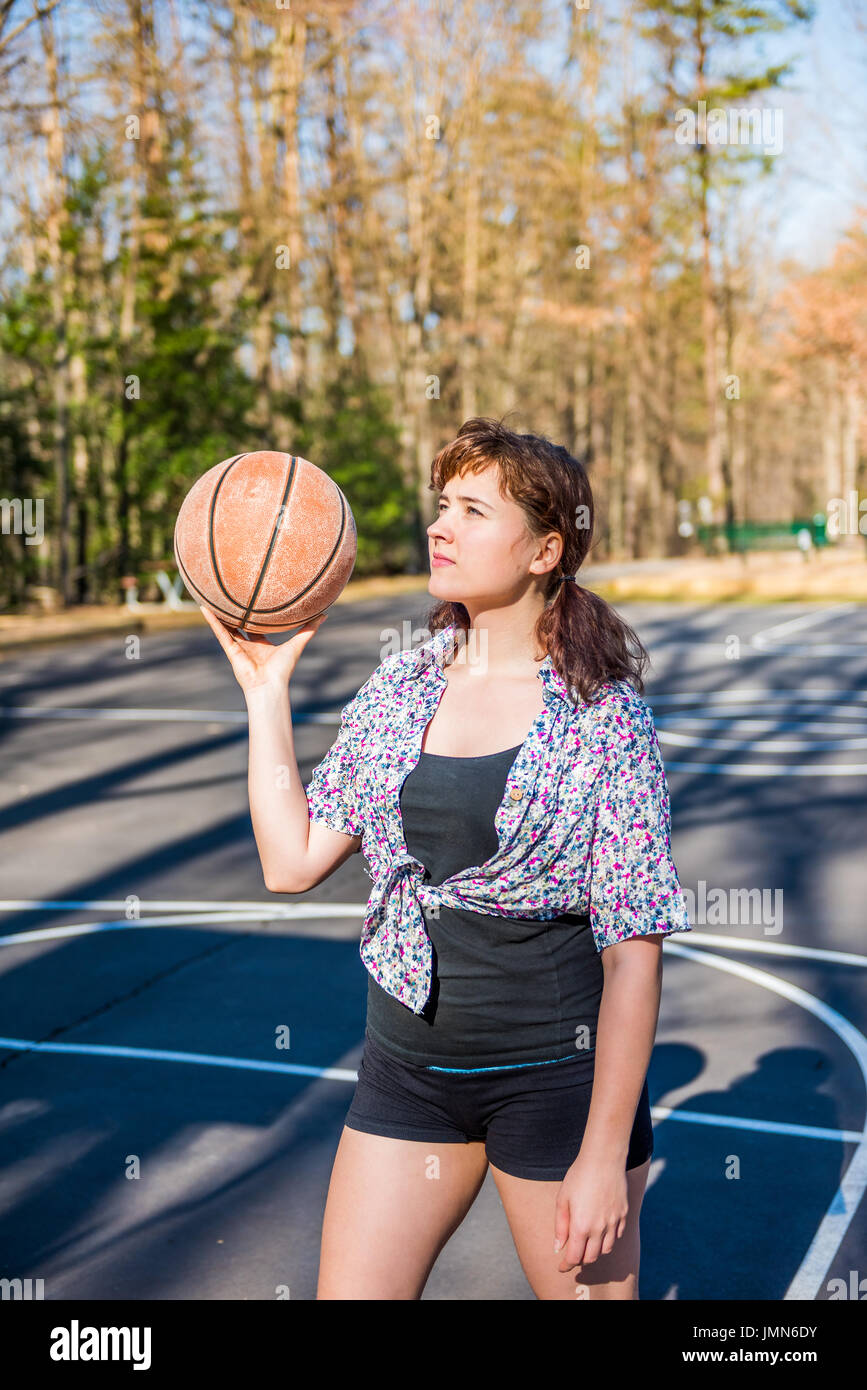 Young fit woman aiming basketball in playground Stock Photo - Alamy
