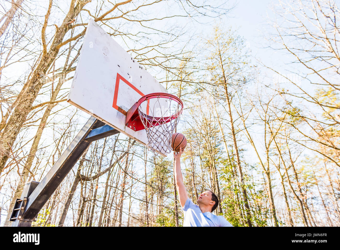 Young fit muscular man jumping up throwing basketball into hoop Stock ...