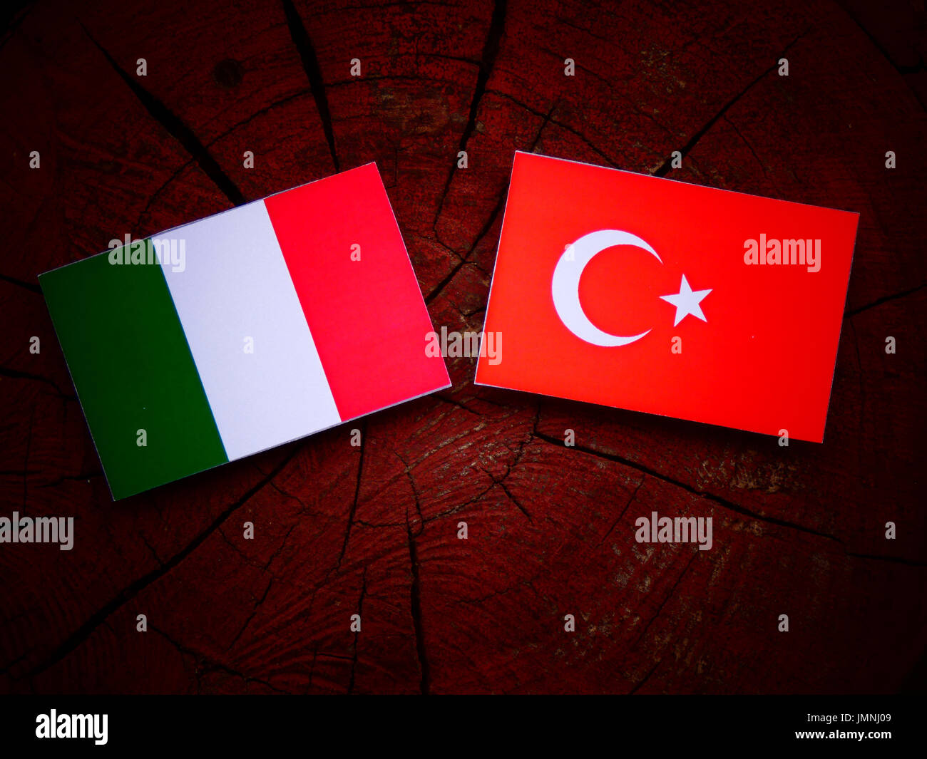 Italian flag with Turkish flag on a tree stump isolated Stock Photo - Alamy