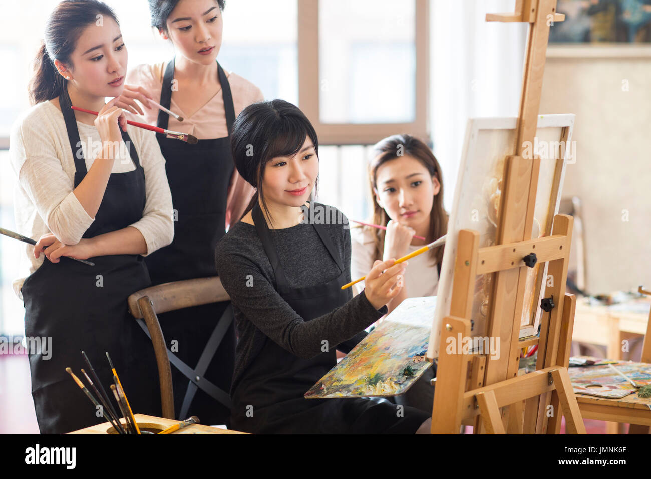 Art teacher with young women in studio Stock Photo - Alamy
