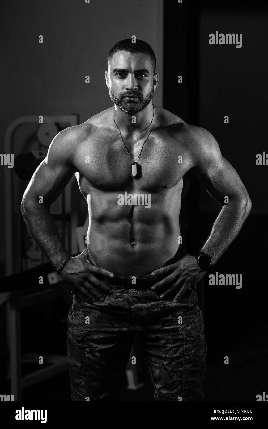 Handsome Young Man Standing Strong In Army Pants And Flexing Muscles ...