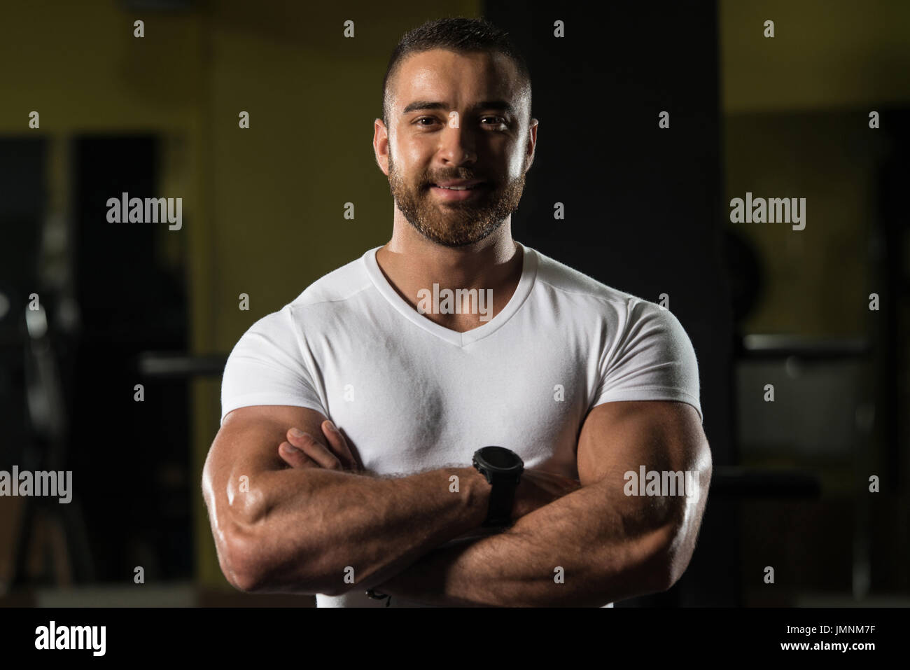 Handsome Young Man Standing Strong In White T-shirt And Flexing Muscles ...