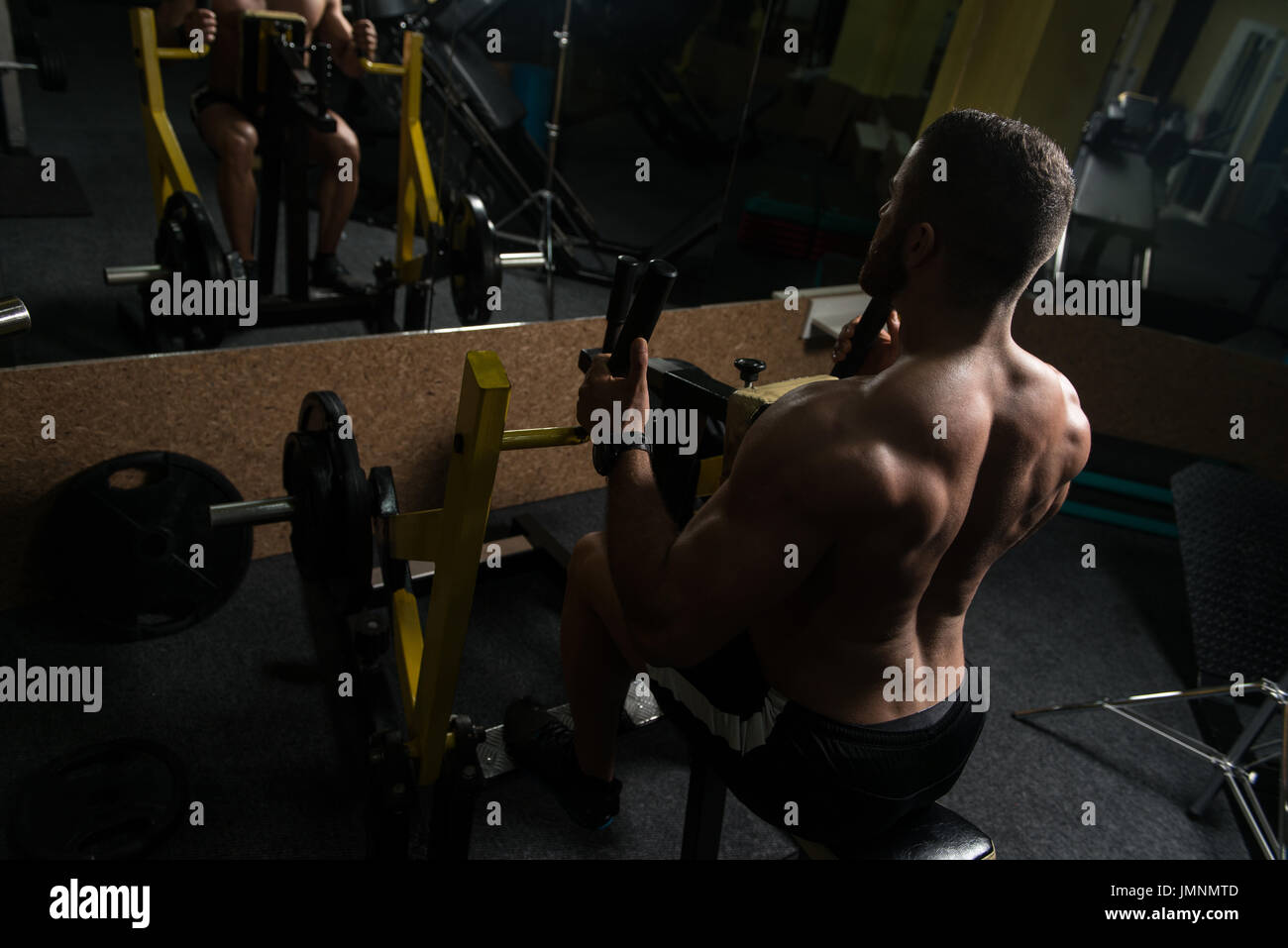 Handsome Bodybuilder Doing Heavy Weight Exercise For Back On Machine ...