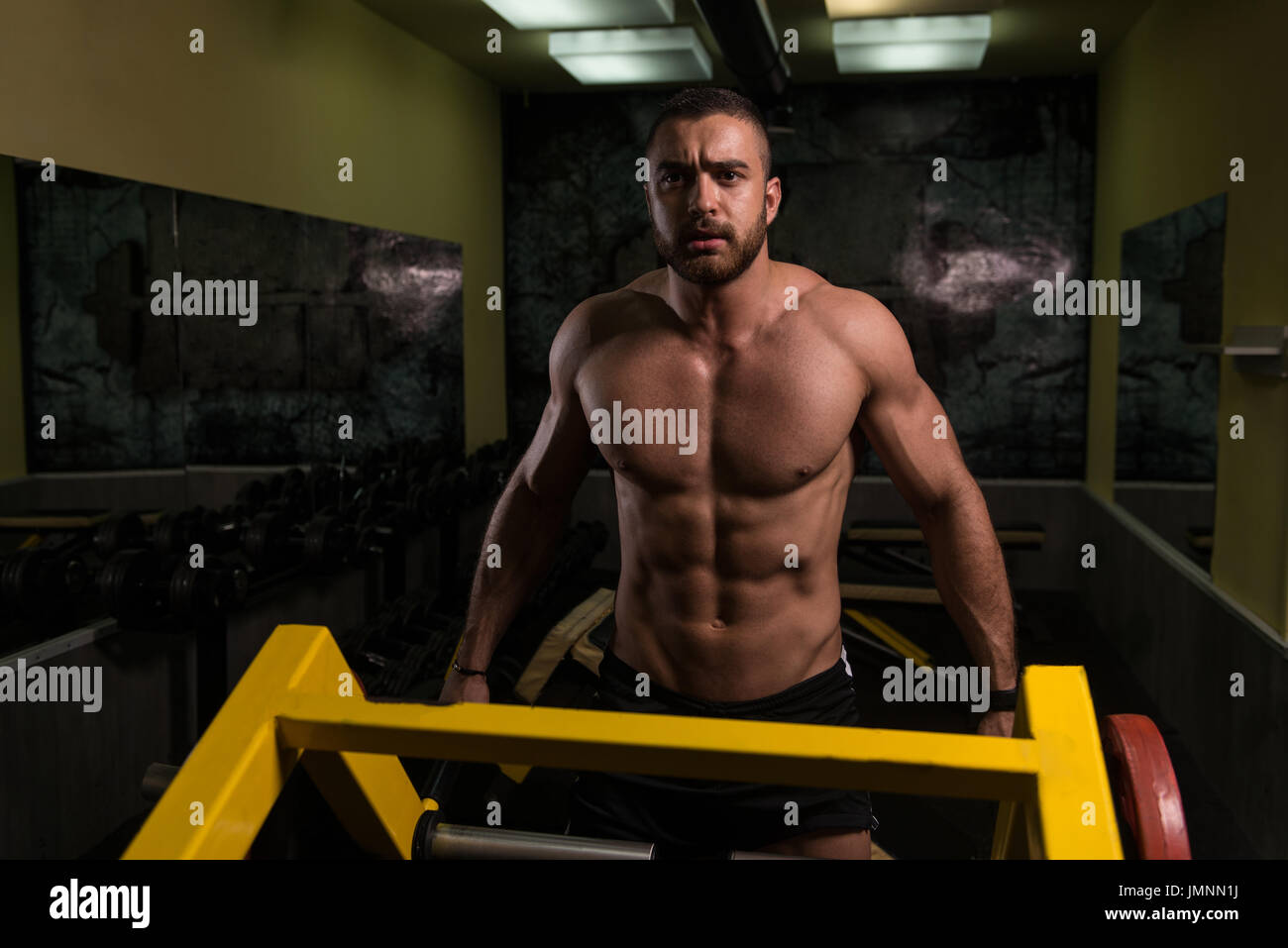 Model Doing Heavy Weight Exercise For Trapezius On Machine Stock Photo ...