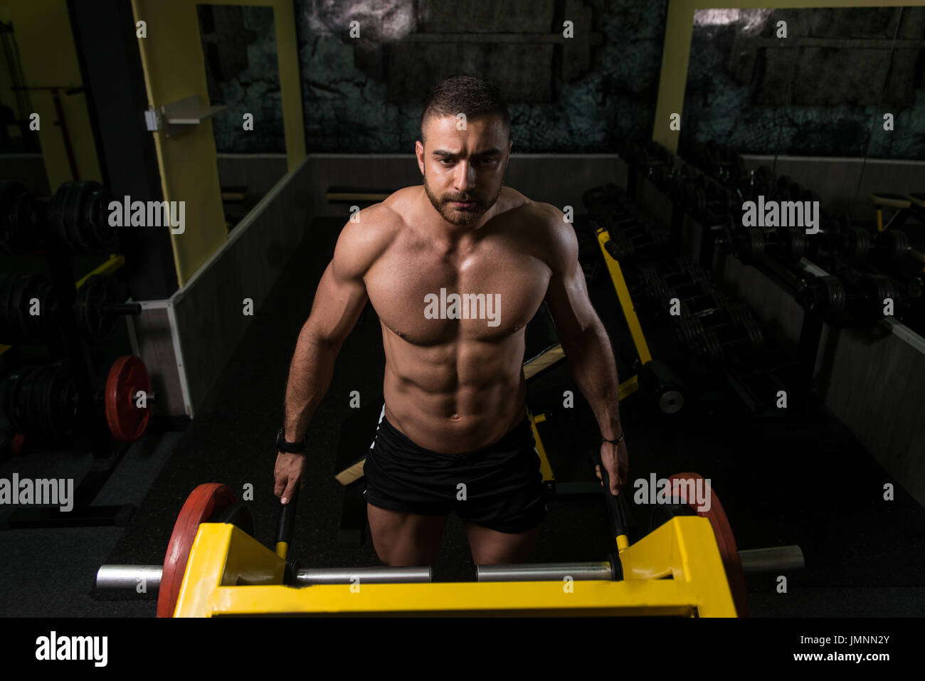 Model Doing Heavy Weight Exercise For Trapezius On Machine Stock Photo ...