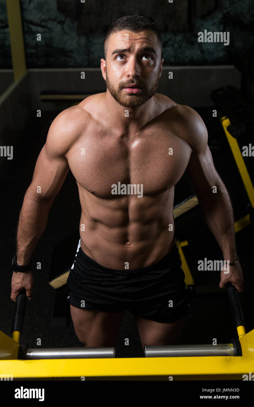Model Doing Heavy Weight Exercise For Trapezius On Machine Stock Photo ...