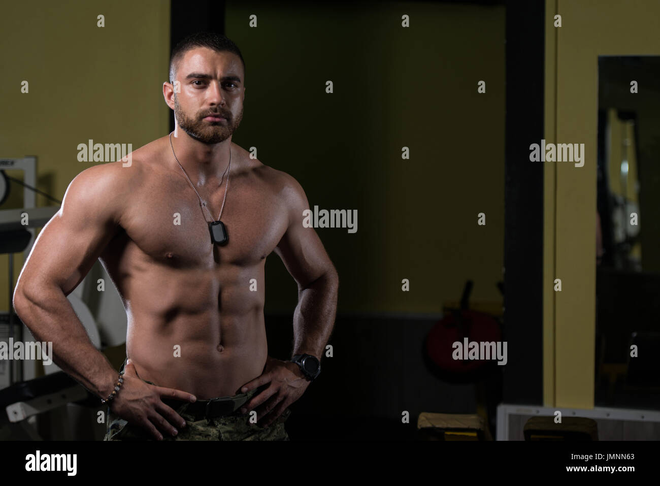 Handsome Young Man Standing Strong In Army Pants And Flexing Muscles ...