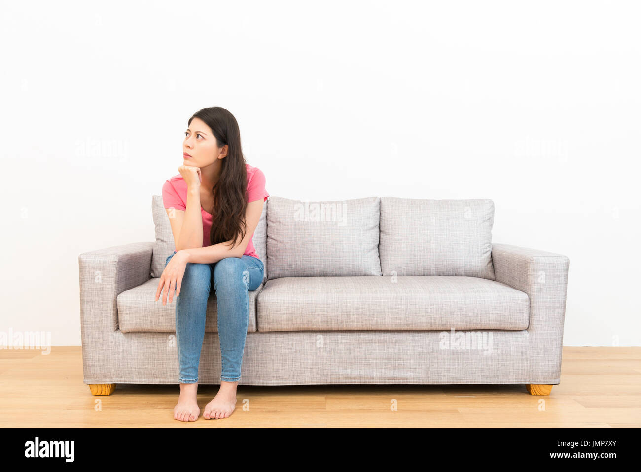 serious woman angry back to white background sitting on couch sofa in ...
