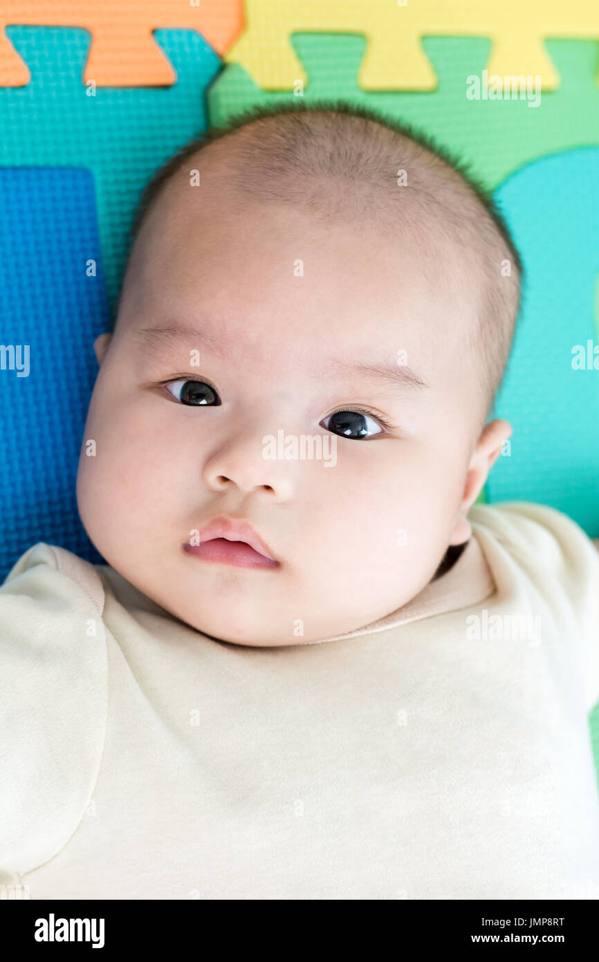 Portrait of a little adorable newborn infant baby girl lying on back on ...