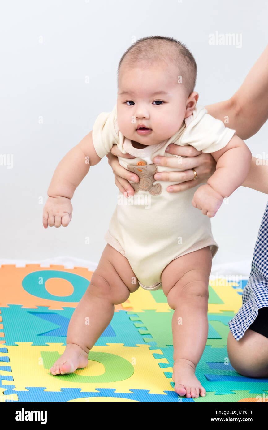 Portrait of a little adorable newborn infant baby girl standing up with ...